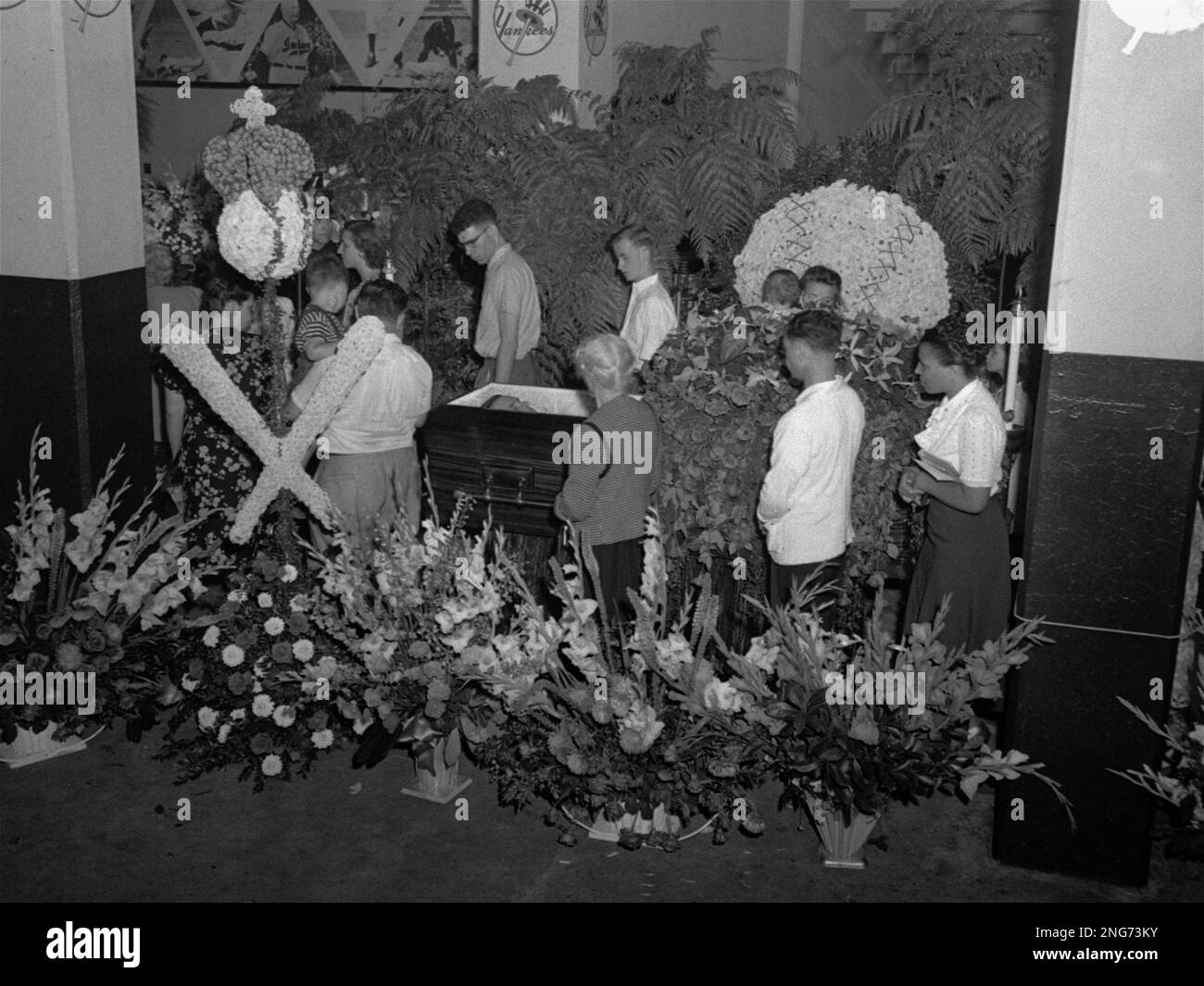 Men, women, and children file past the casket containing the body of ...