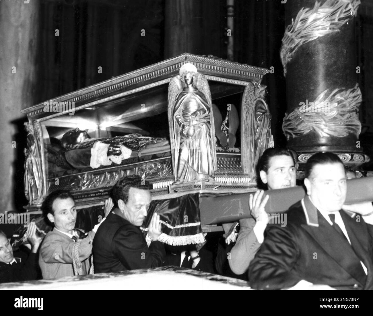 The crystal urn containing the body of Saint Pius X, is carried on ...
