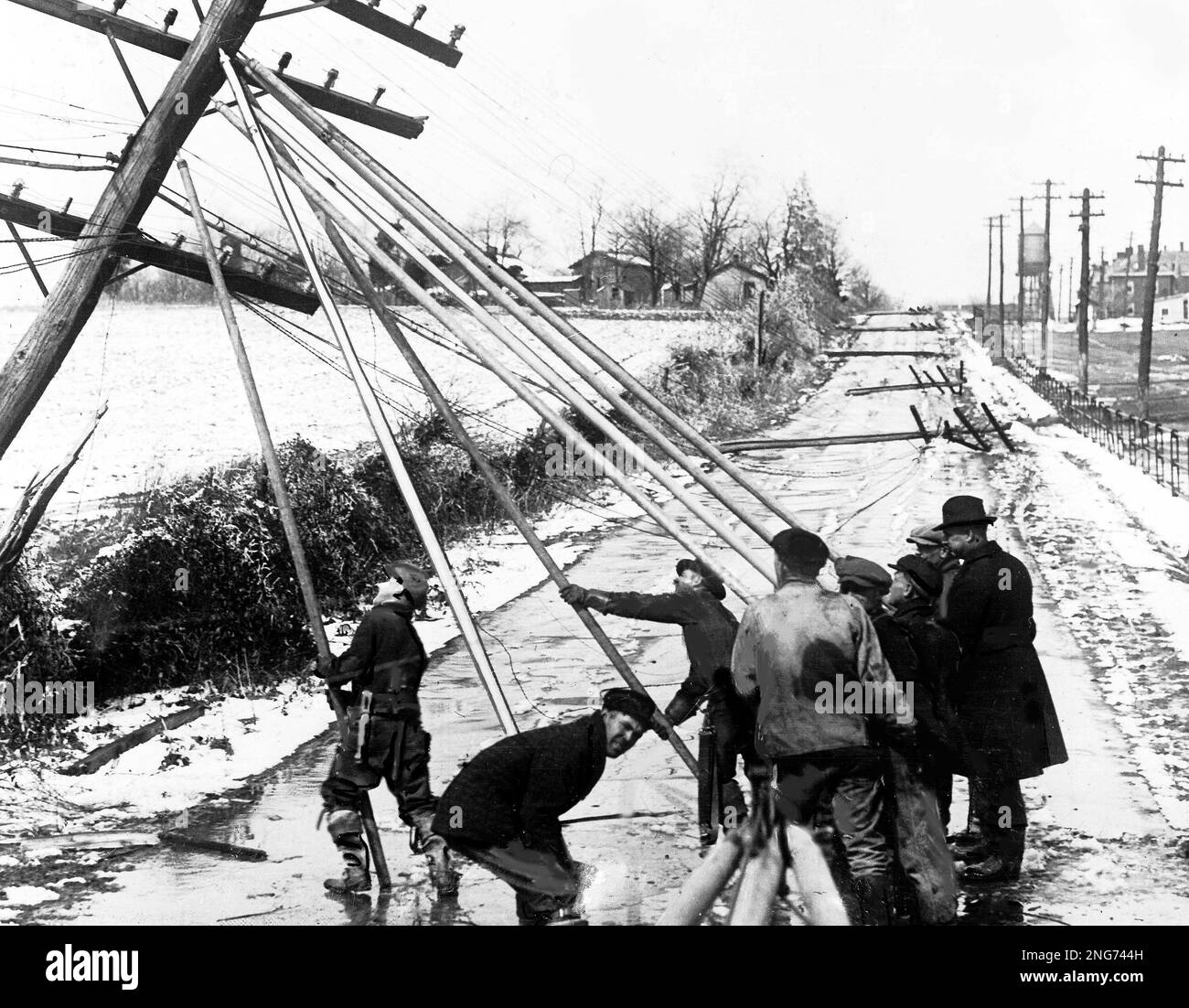 Firemen and other workers try to restore telegraph poles which were ...