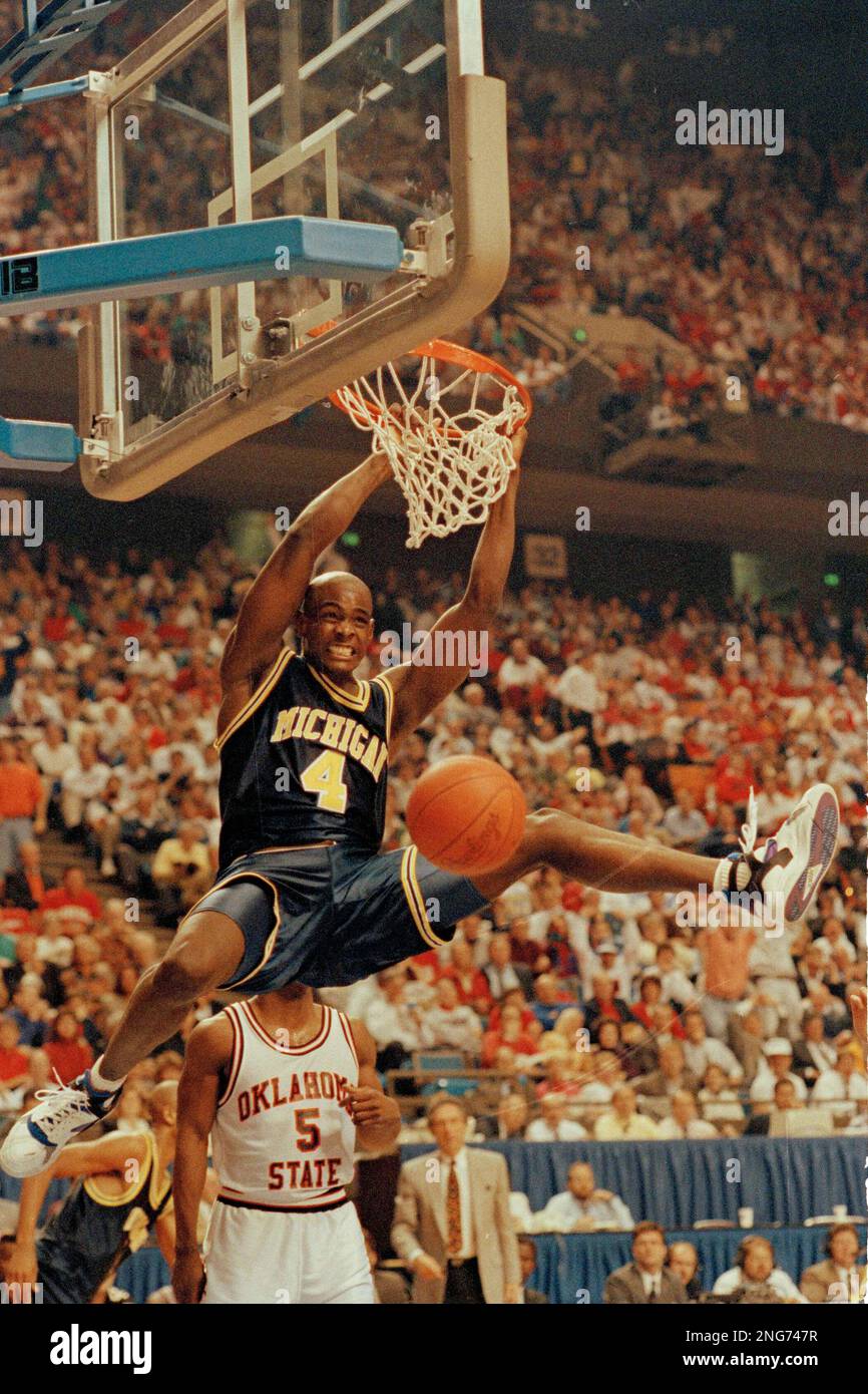 Michigan's Chris Webber (4) rips one down over Oklahoma State's Corey ...
