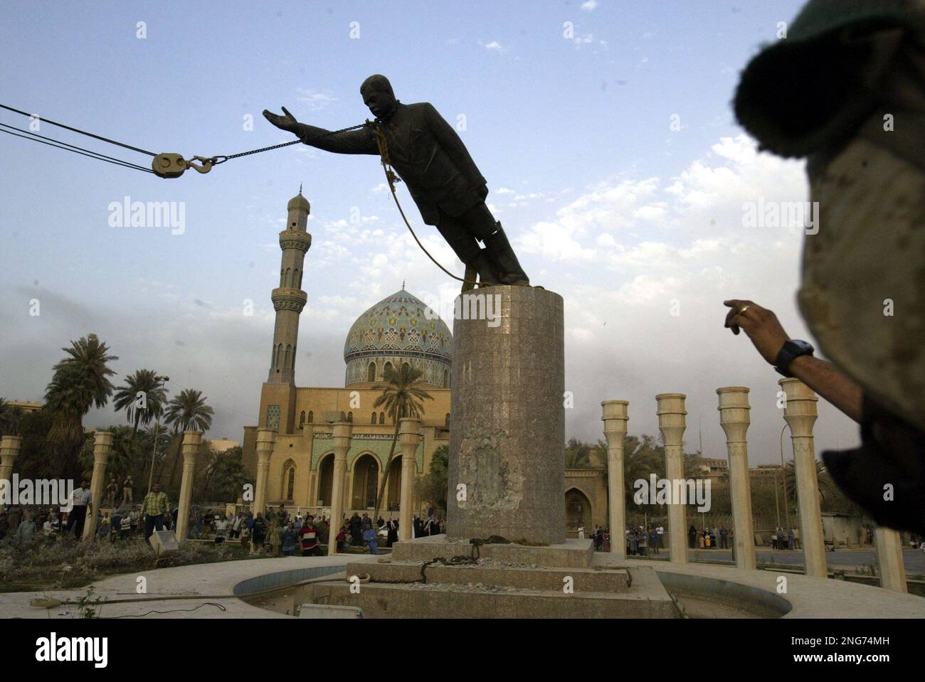 **FILE** A U.S. Marine watches a statue of Saddam Hussein being toppled ...