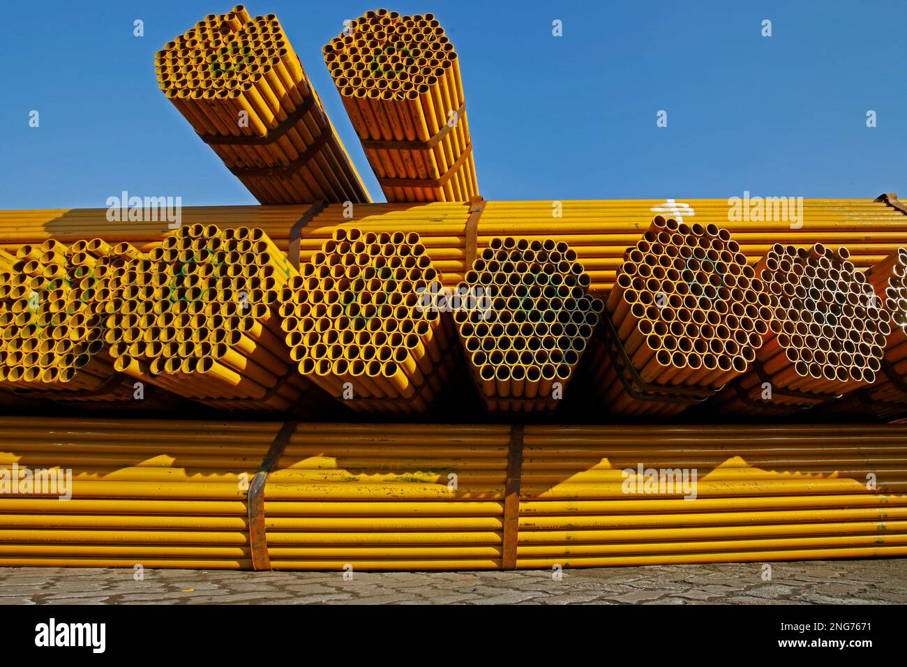 Yellow stacked steel pipe Stock Photo - Alamy