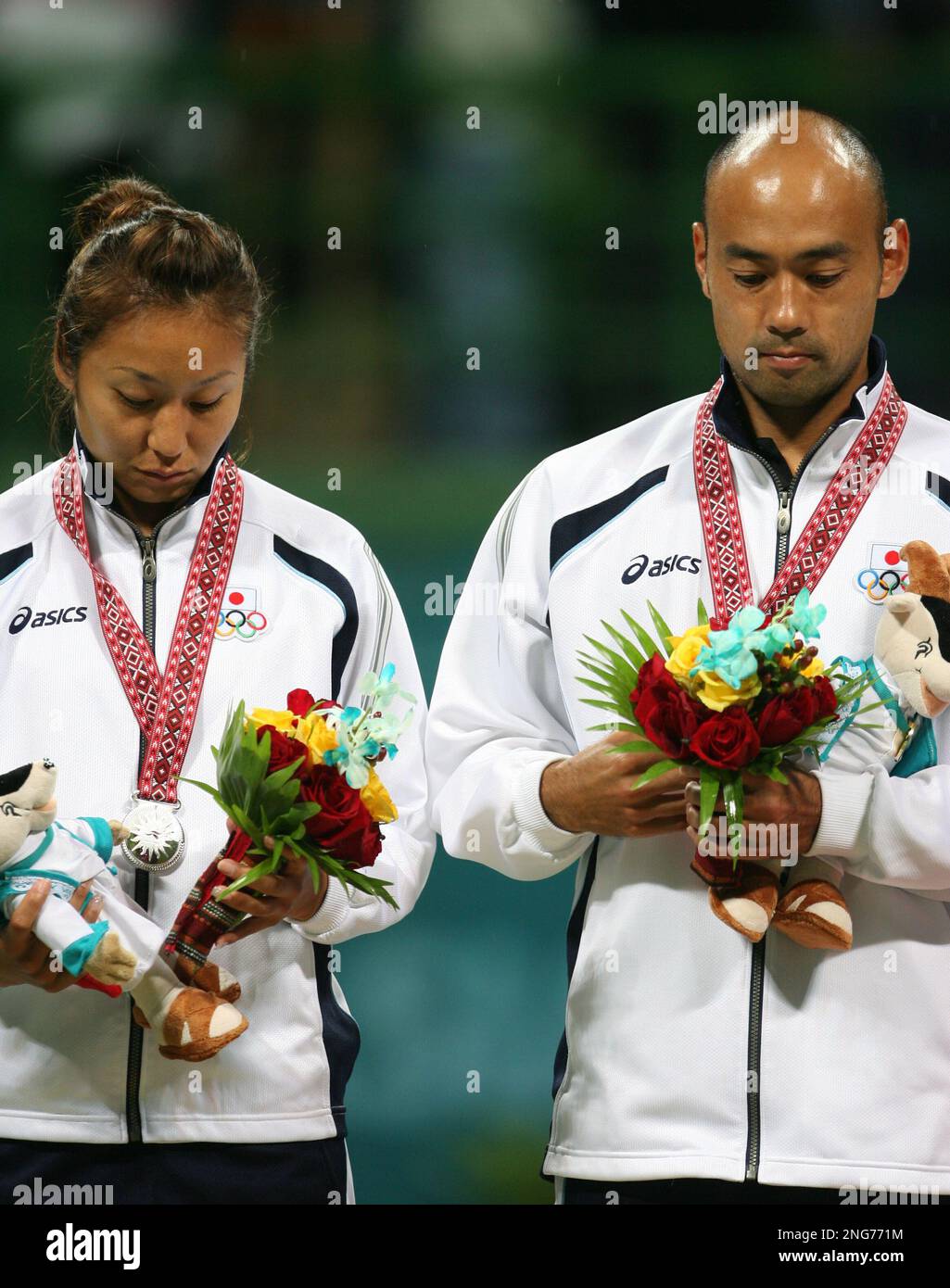 Japan's Satoshi Iwabuchi, right, and Akiko Morigami stand on the medals podium for the Asian ...