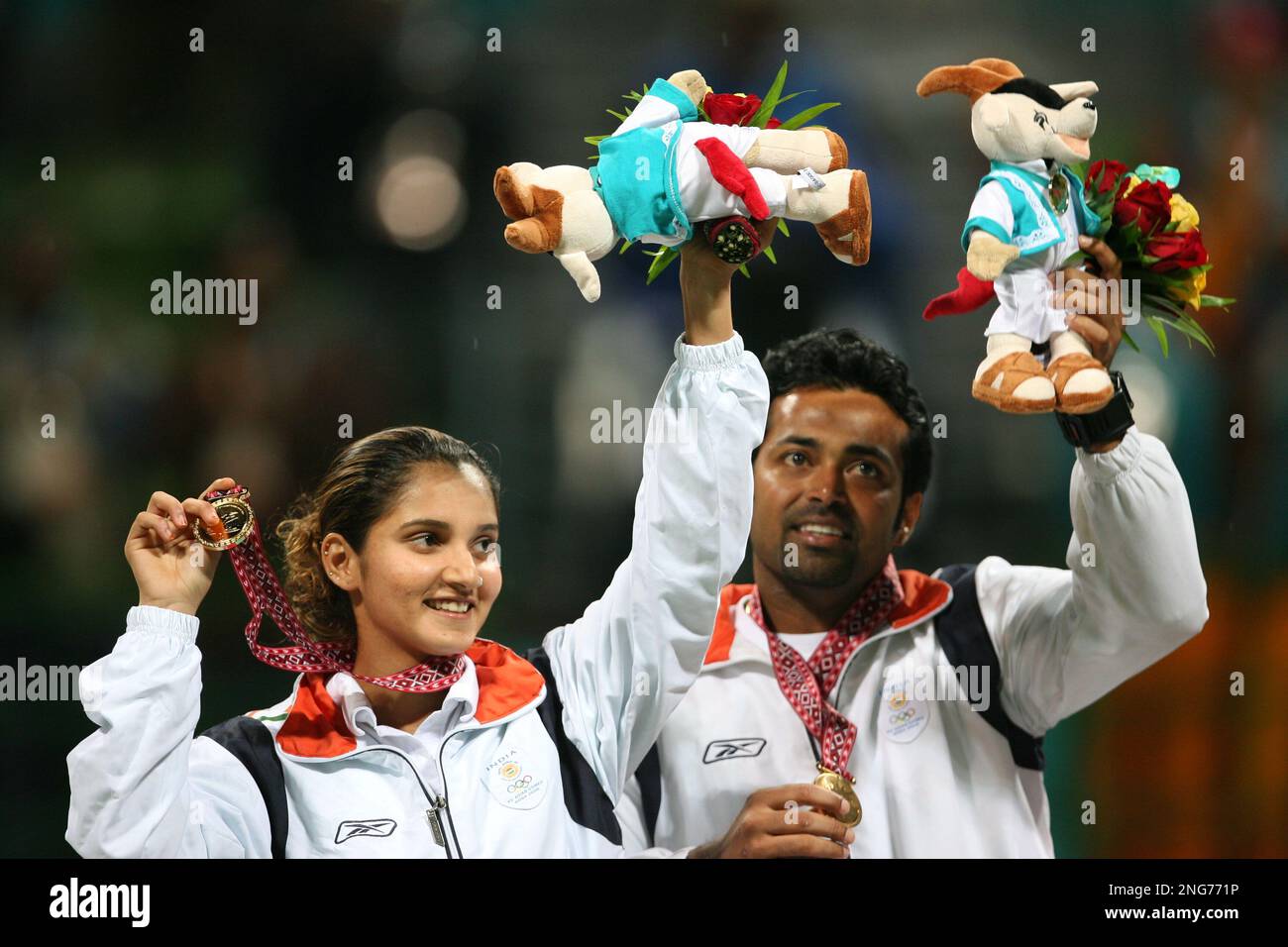 India's Leander Paes, right, and Sania Mirza show their gold medals for the Asian Games Tennis ...