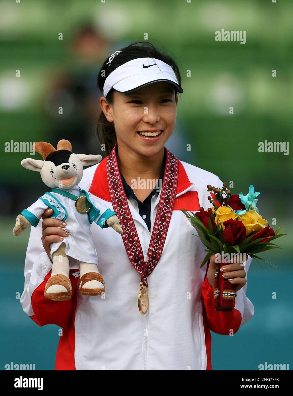 China's Zheng Jie smiles at the medals podium for Women's Singles Tennis final at the Asian ...