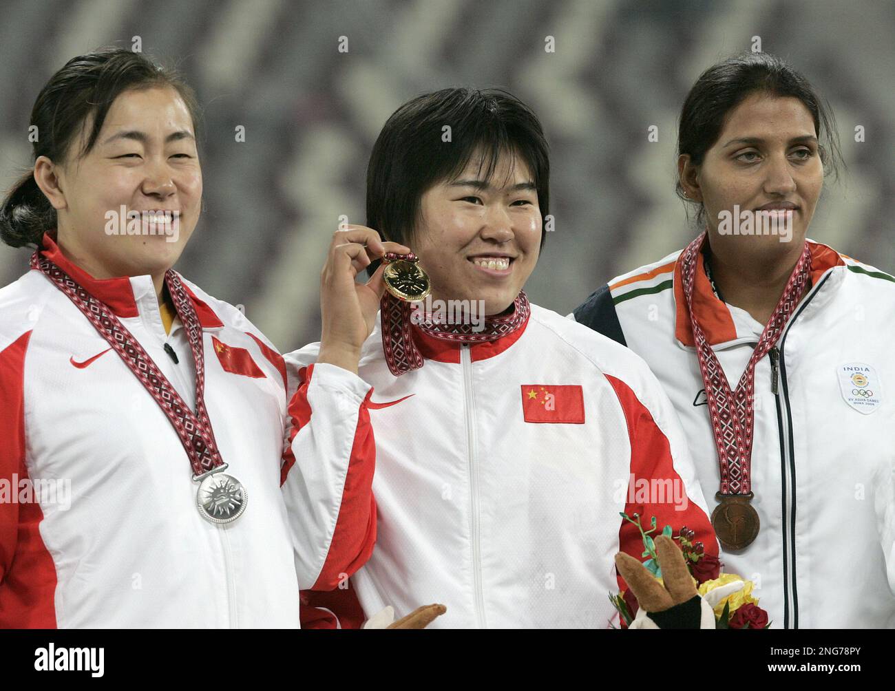 India's Krishna Punia, bronze, China's Song Aimin, gold, and China's Ma Xuejun, silver, from ...
