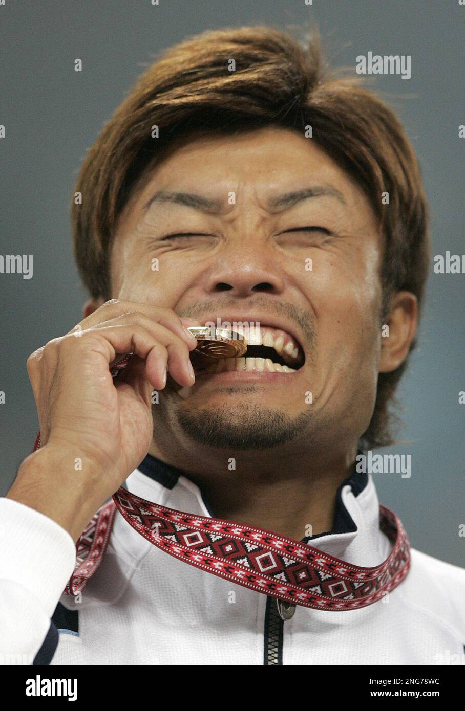 Japan's Shingo Suetsugu bites the gold medal he won in the final of the ...