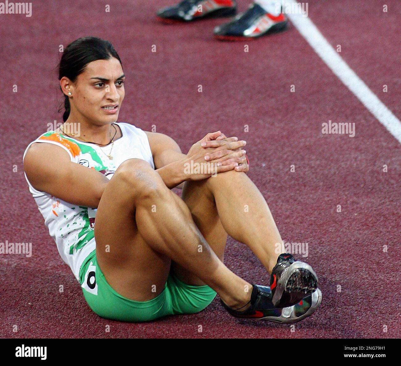 India's Manjeet Kaur, left, who took the silver sits on the track after ...