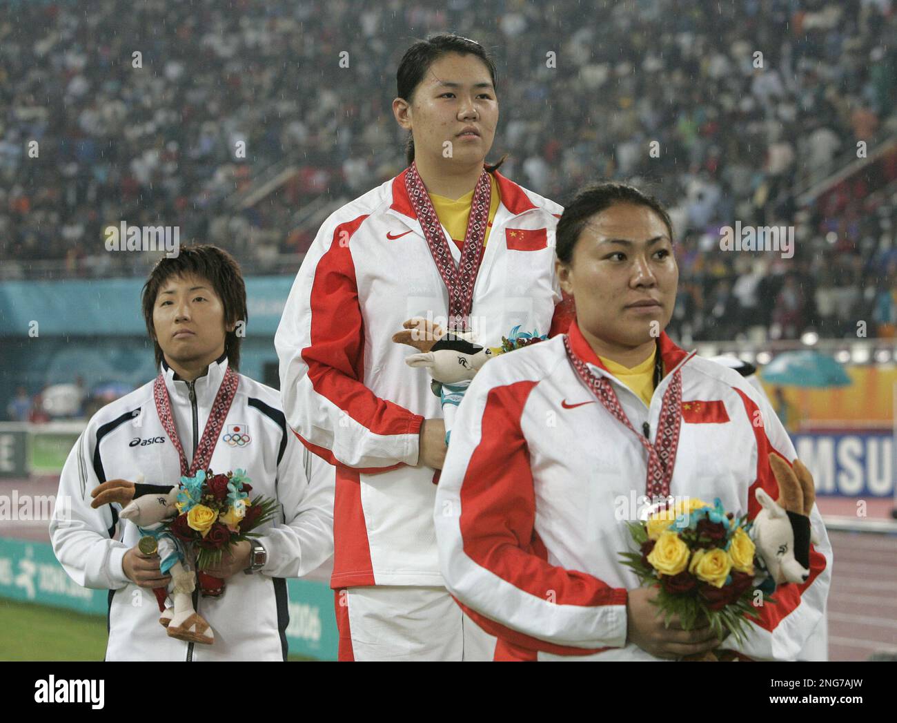 China's Zhang Wenxiu, center, the gold medal winner is flanked at right ...