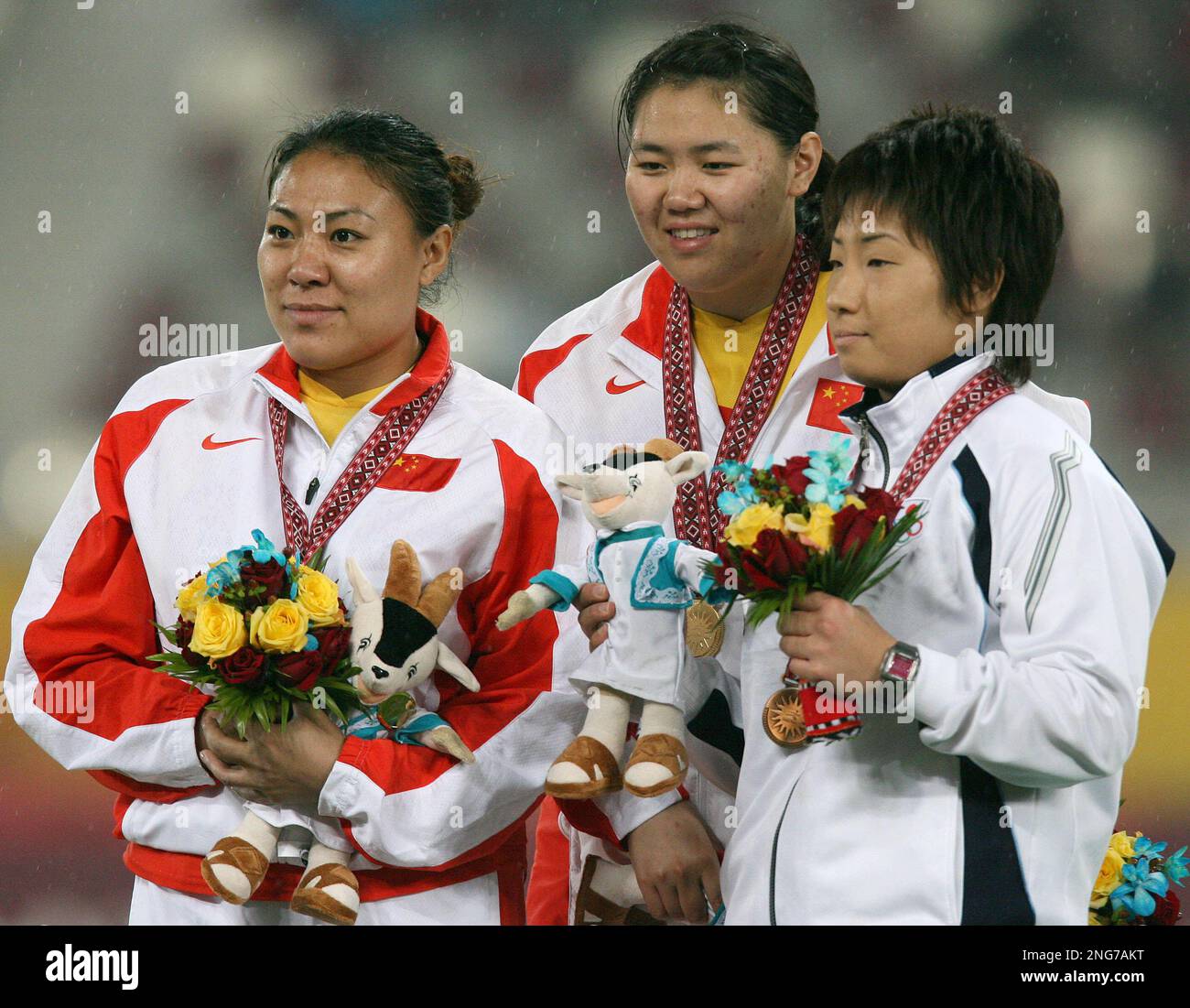 China's Zhang Wenxiu, center, the gold medal winneri is flanked at left ...