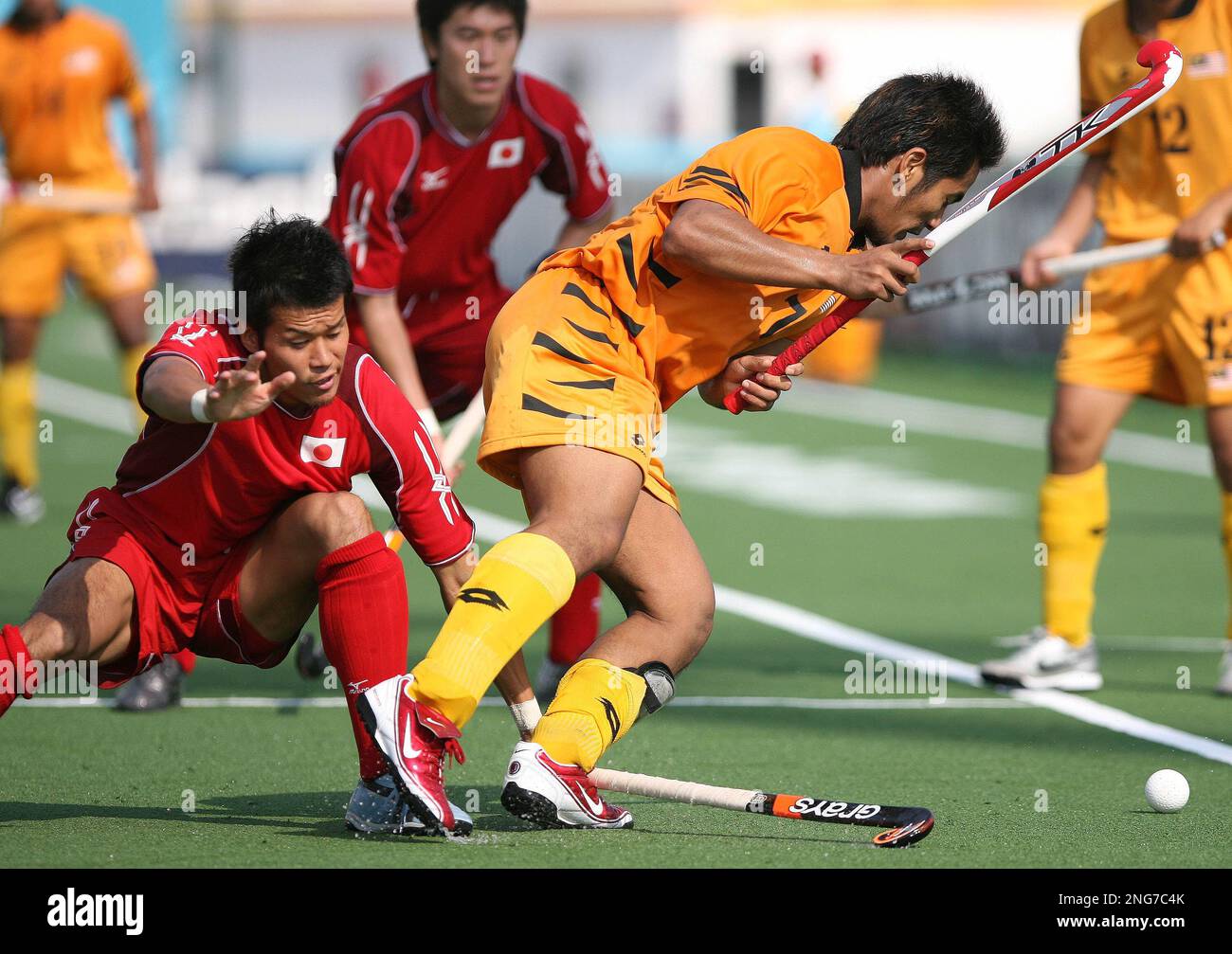 Japan's Kenichi Katayama, left, tries to tackle a Malaysian player ...