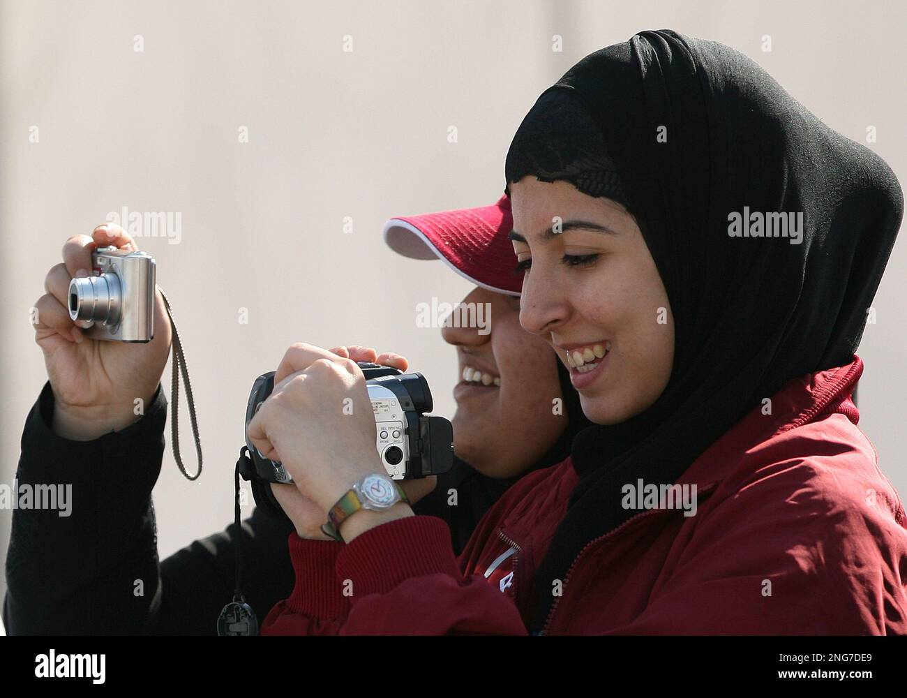 Qatari officials associated with the shooting team take photos of ...