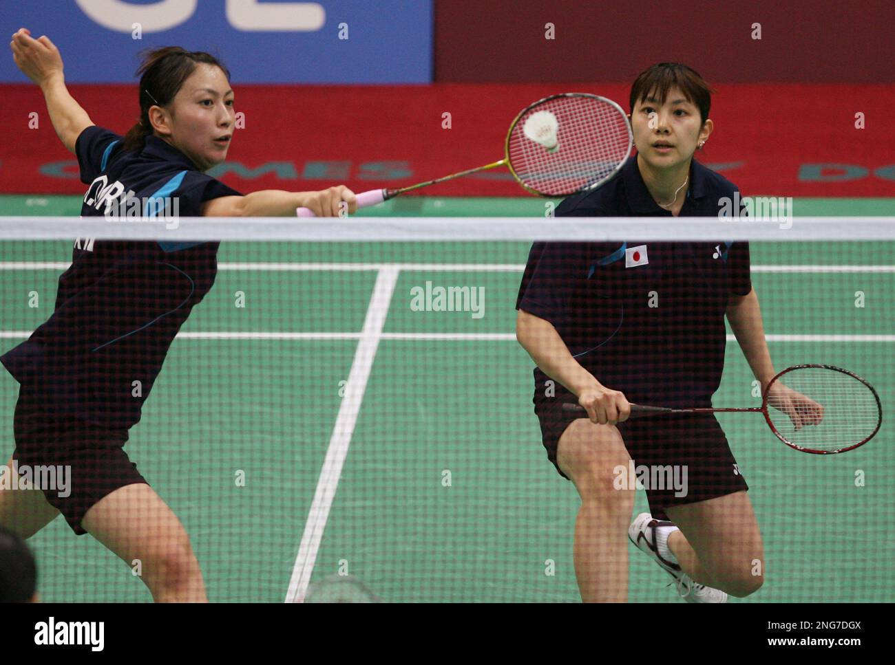 Japan's Kumiko Ogura, left, returns the shuttlecock as Reiko Shiota ...