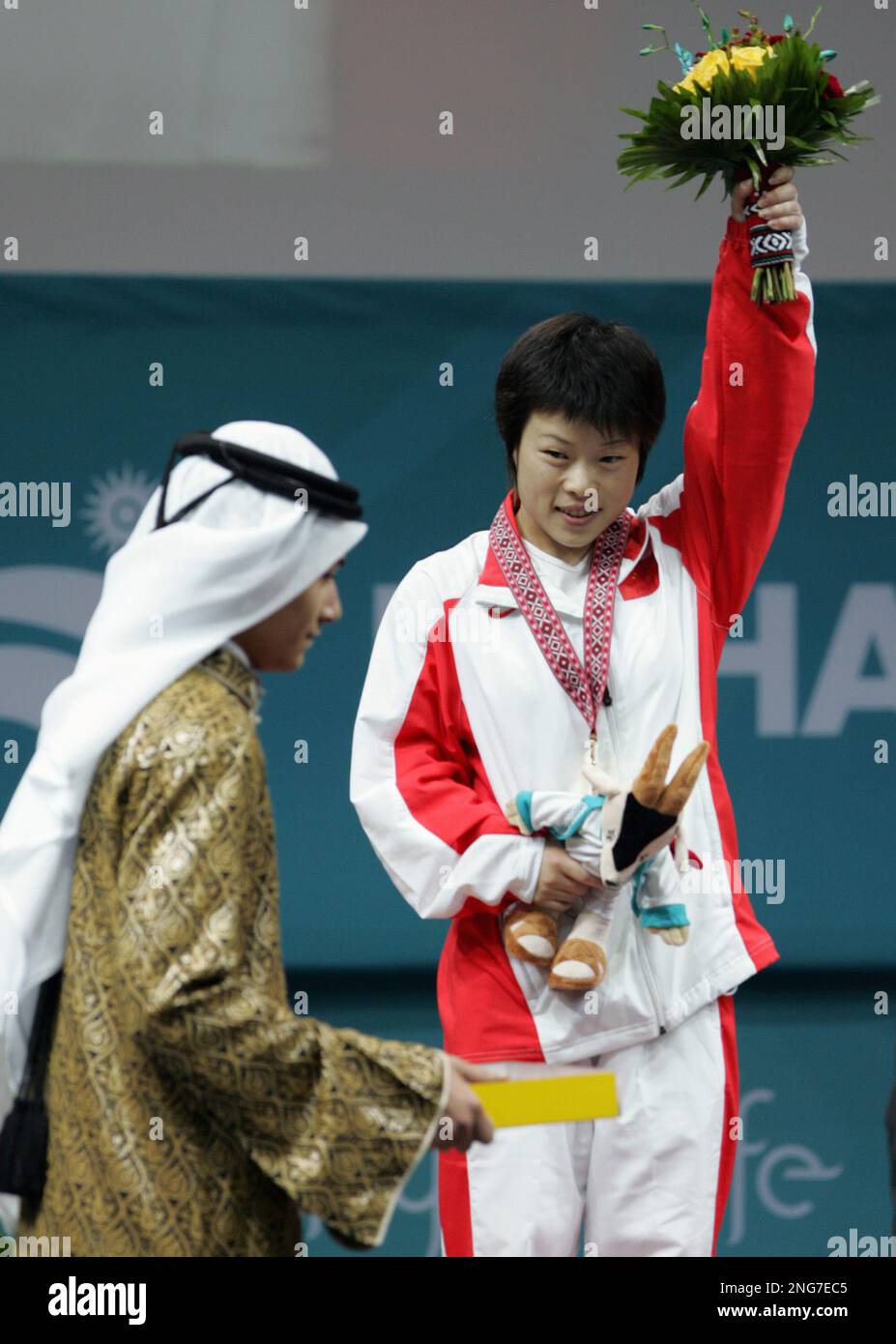 China's Wang Mingjuan waves on the podium after winning the gold medal ...
