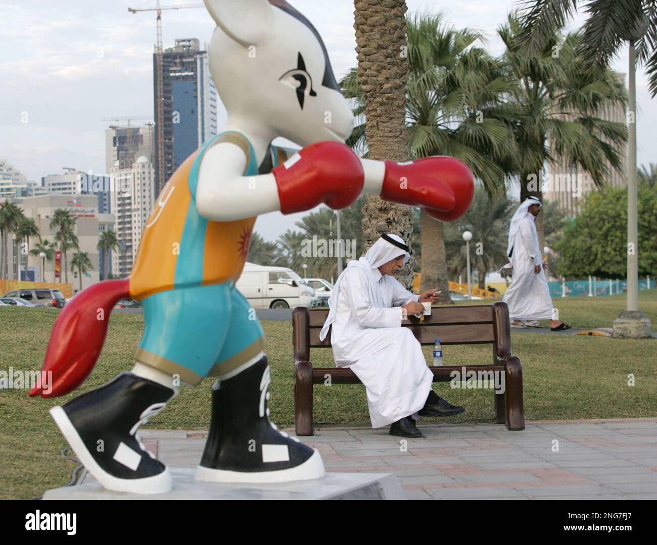 A Qatari man takes a break near a model of Asian Games mascot 'Orry', a ...