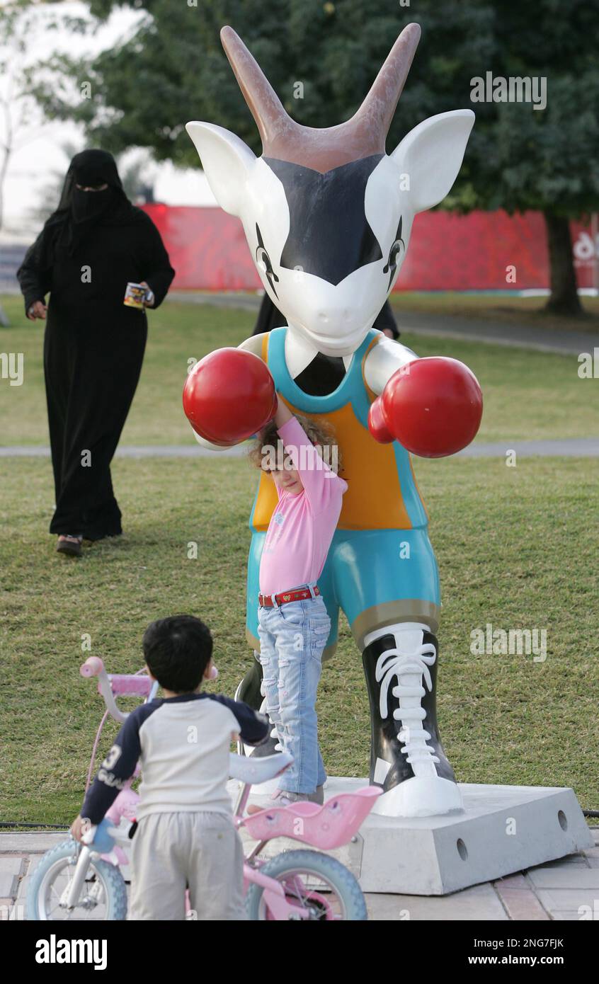 Children play near a model of Asian Games mascot 'Orry', a Qatari Oryx ...