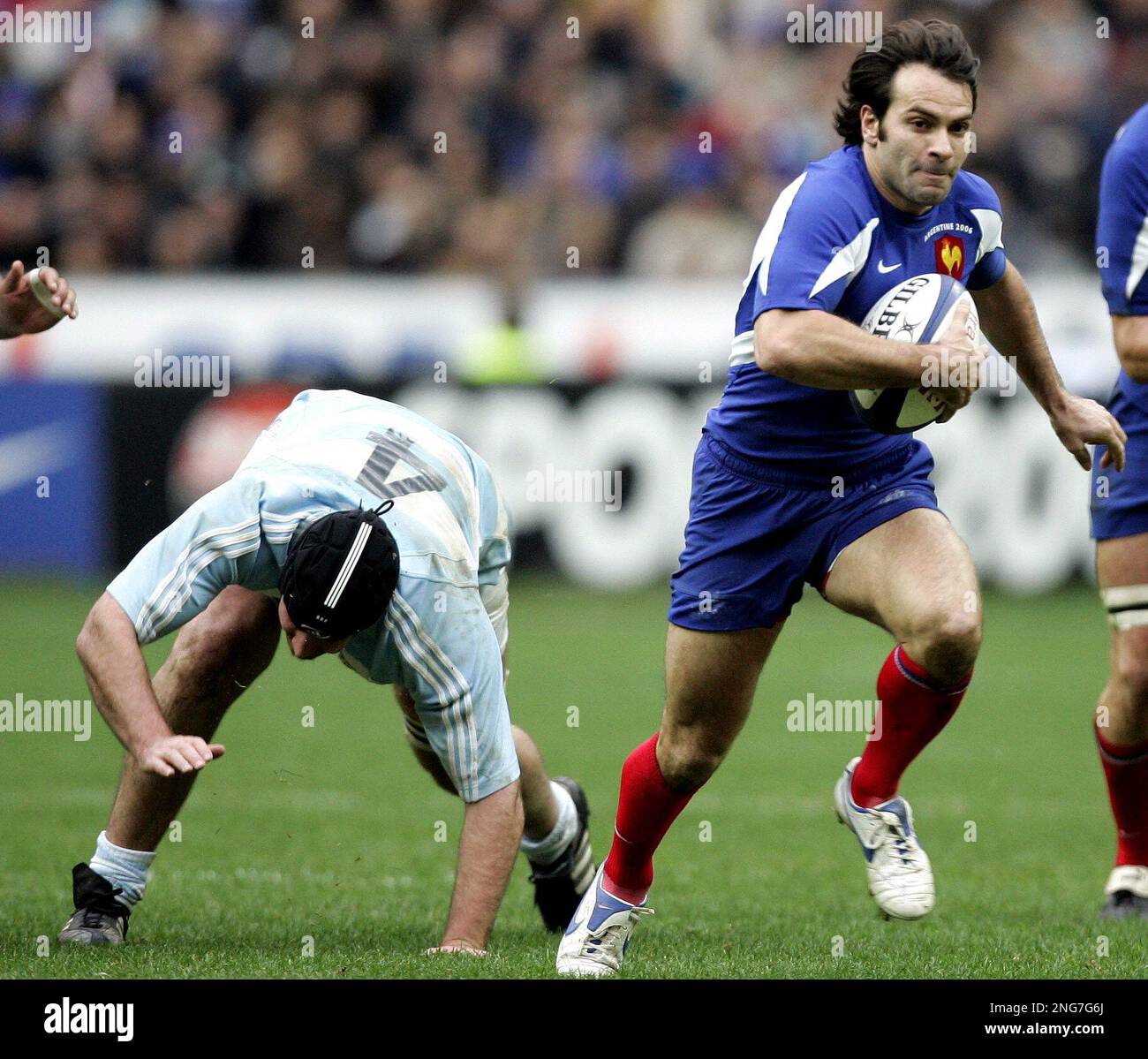 France's Christophe Dominici, right, runs past Argentina's Ignacio ...