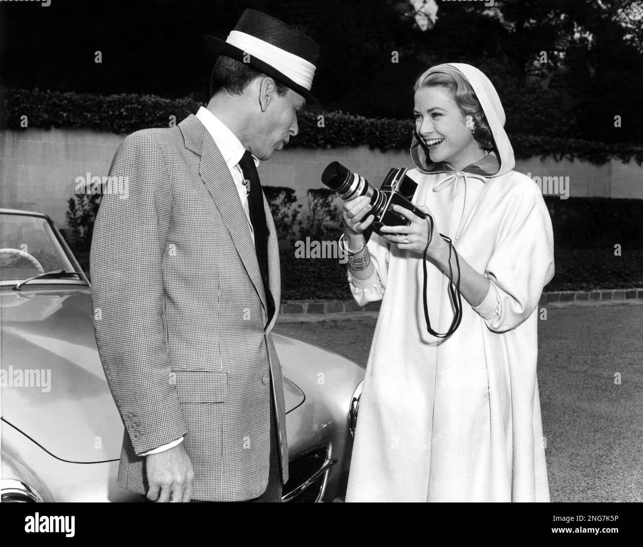 American actress Grace Kelly, right, smiles as she holds a camera in ...