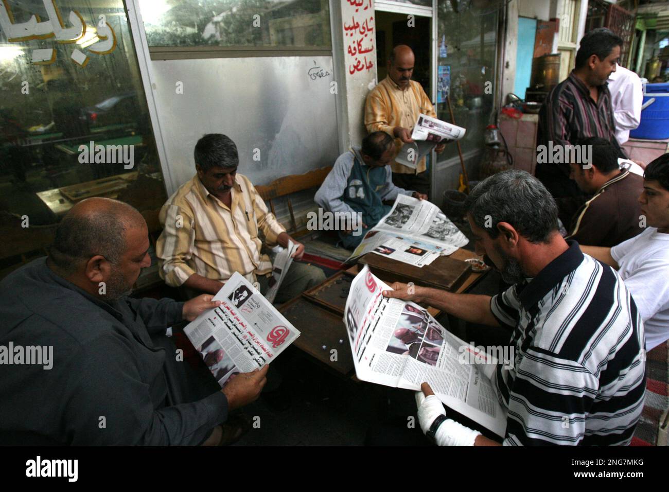 Iraqis read newspapers in Baghdad Monday Nov. 6, 2006 following a death ...