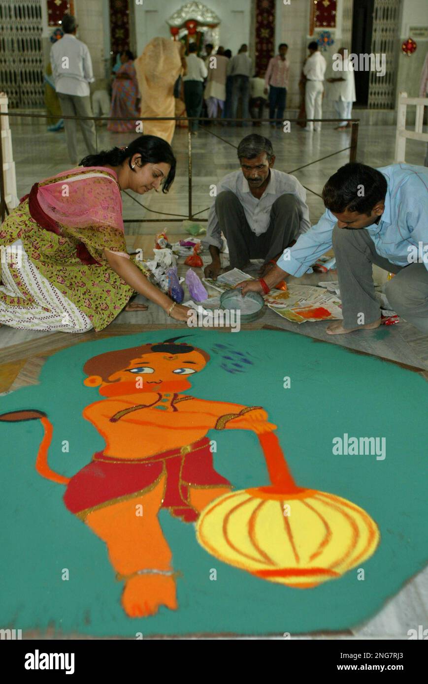 People make a rangoli, colored powder art, of Hindu God Hanuman at the ...