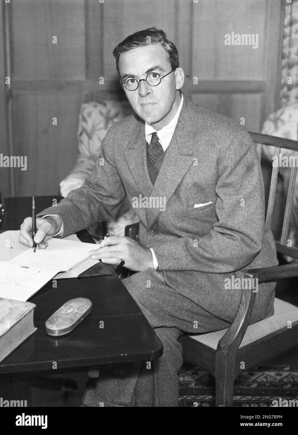 British politician Sir Stafford Cripps at his desk in his home ...