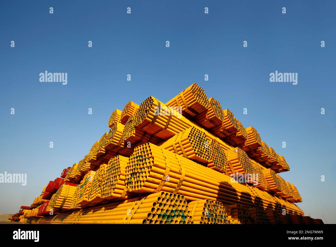 Yellow stacked steel pipe Stock Photo - Alamy
