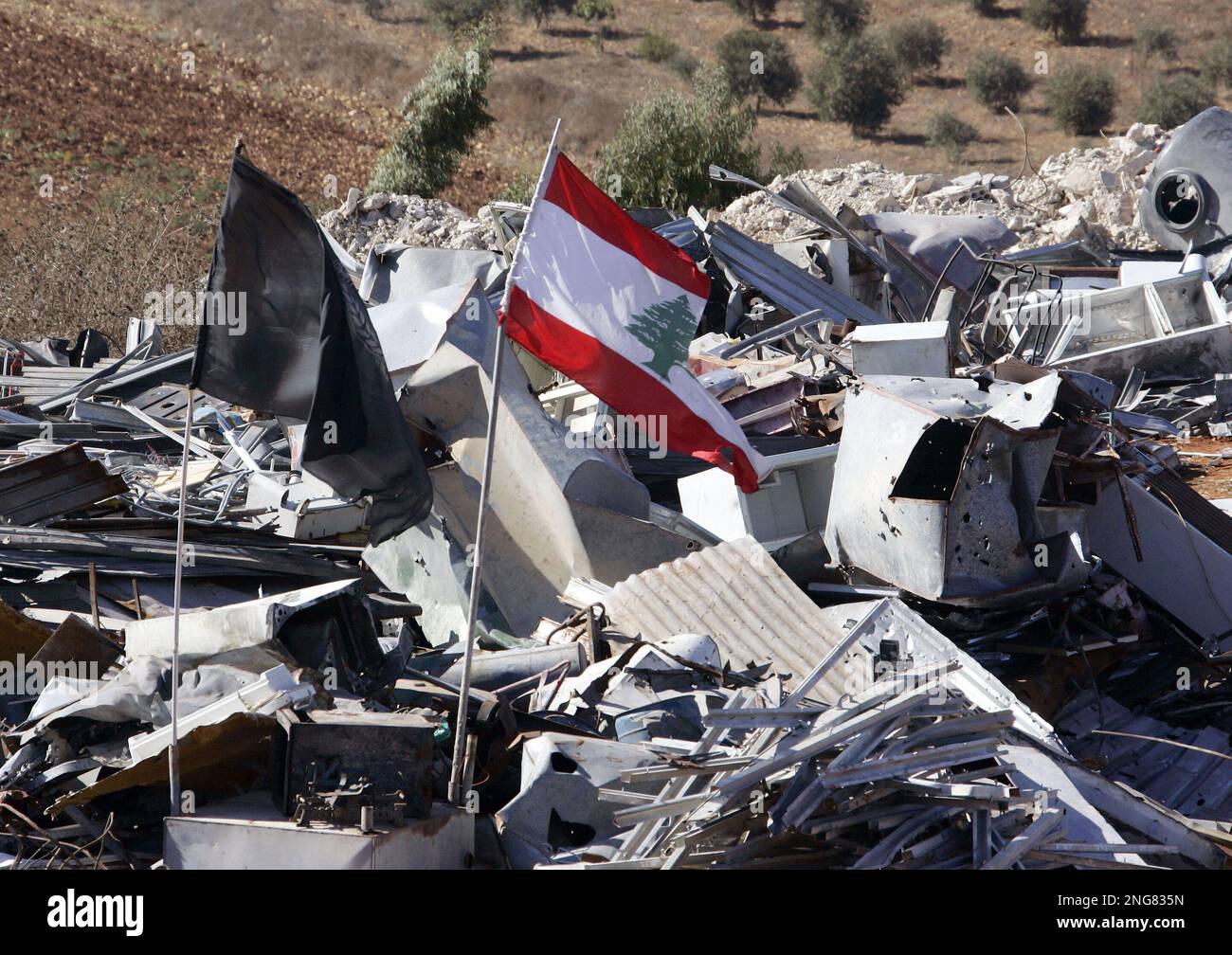 A torn Lebanese flag flaps in the breeze among a pile of metal from the ...
