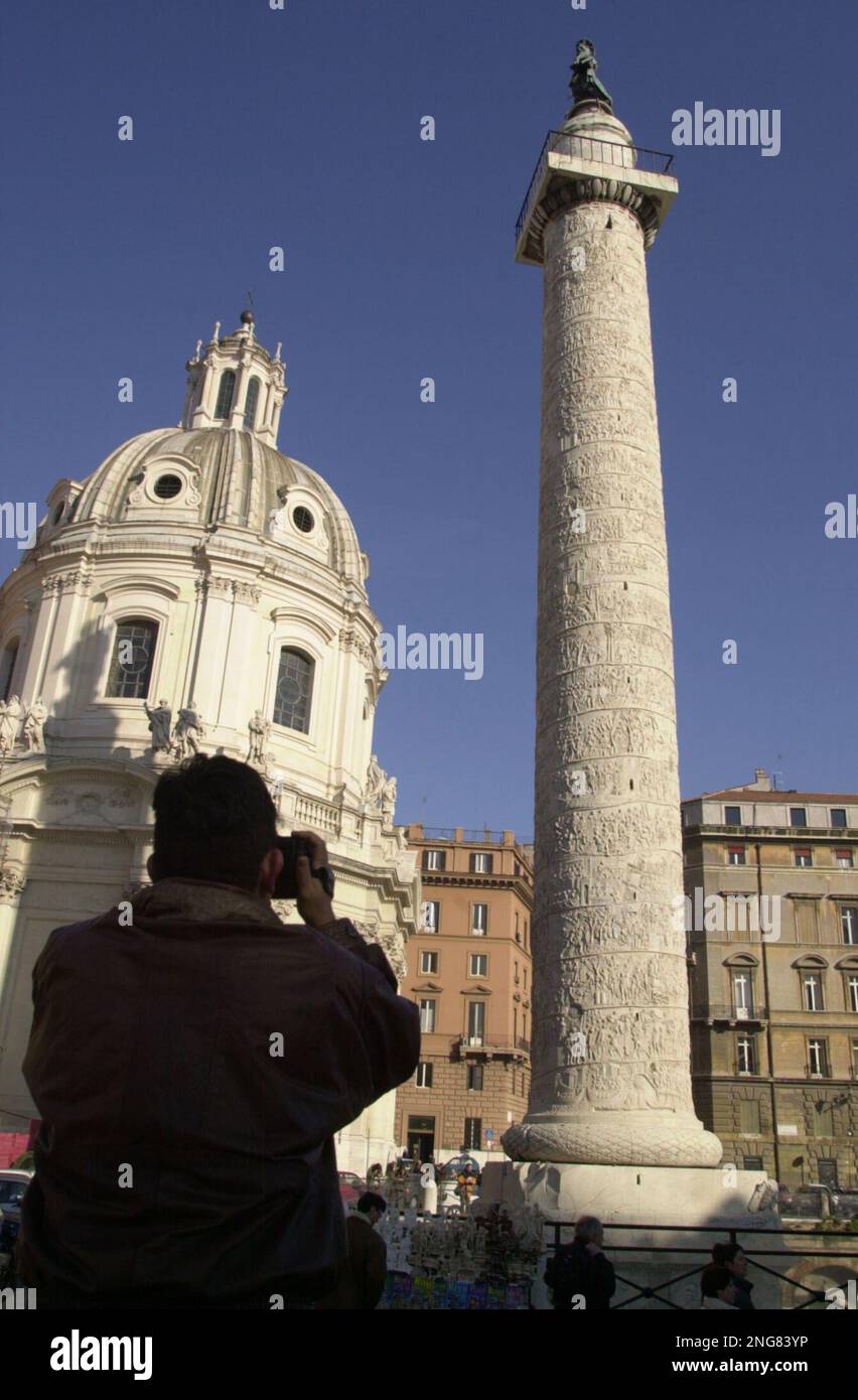 A man takes a photograph of the ancient Roman Emperor Trajan's Column ...
