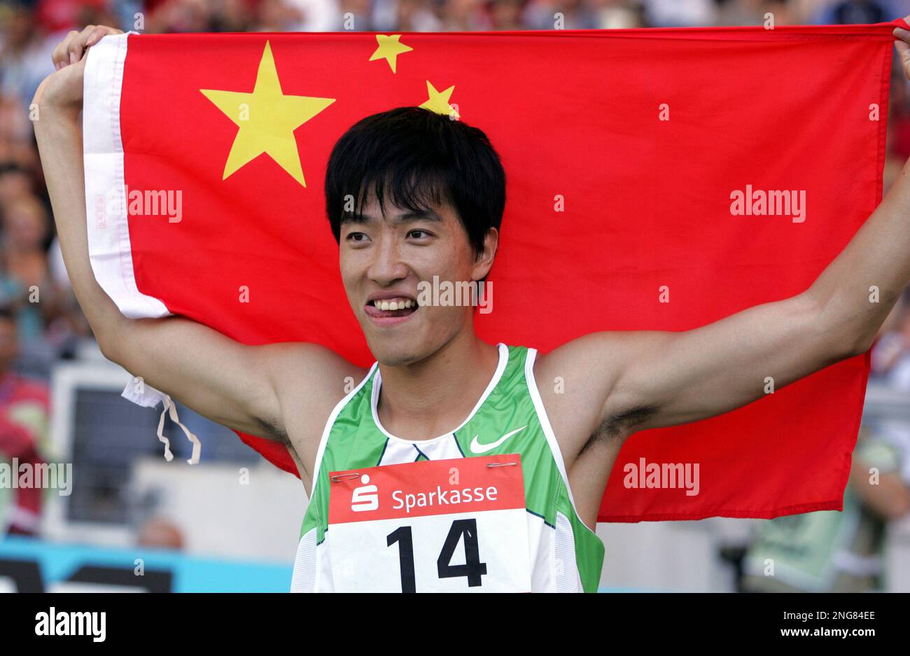 China's Liu Xiang holds the Chinese flag after winning the Men's 110 ...