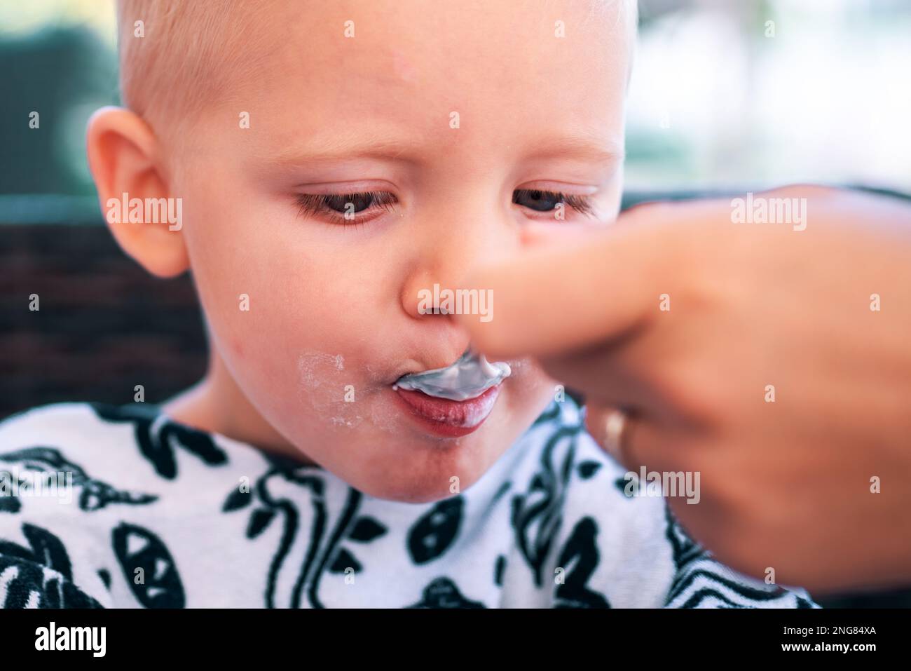 Kid food. Feeding baby boy with spoon. Fatherhood, mother or sister ...