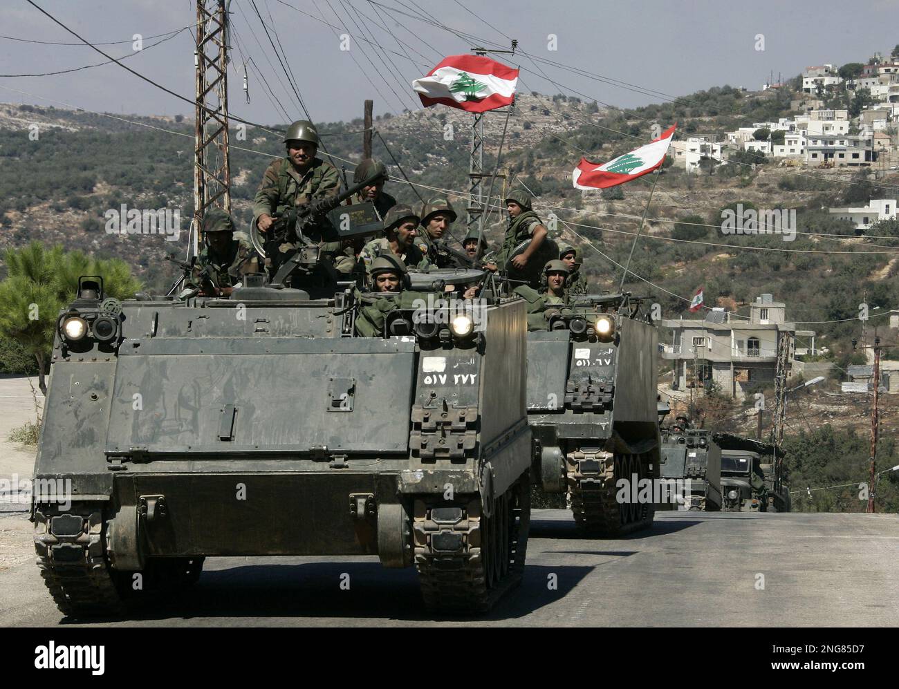 Lebanese armoured personnel carriers drive through the village of Ain ...