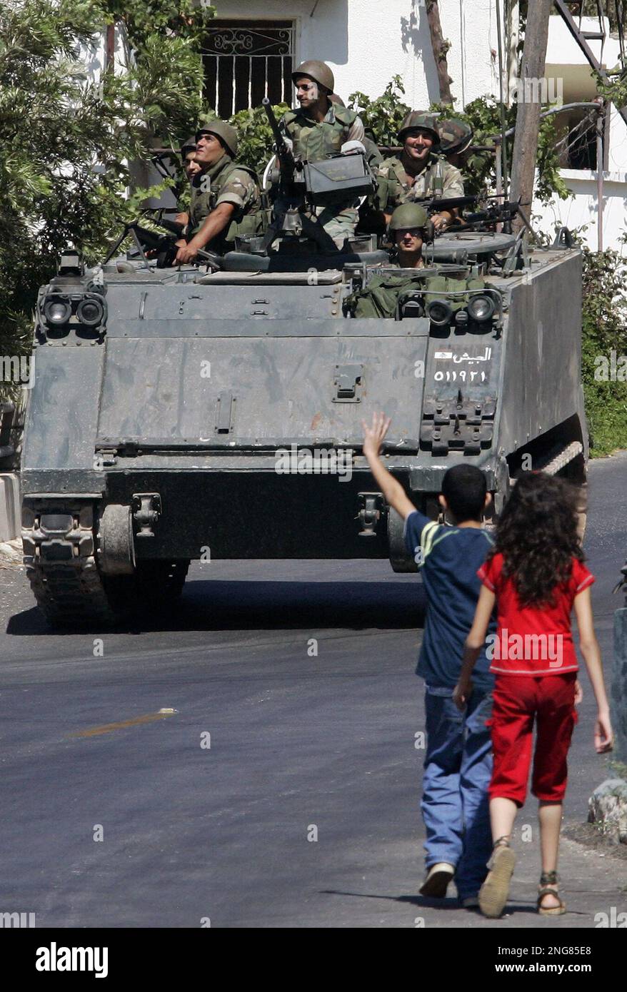 Lebanese children wave to a Lebanese armored personnel carrier driving ...