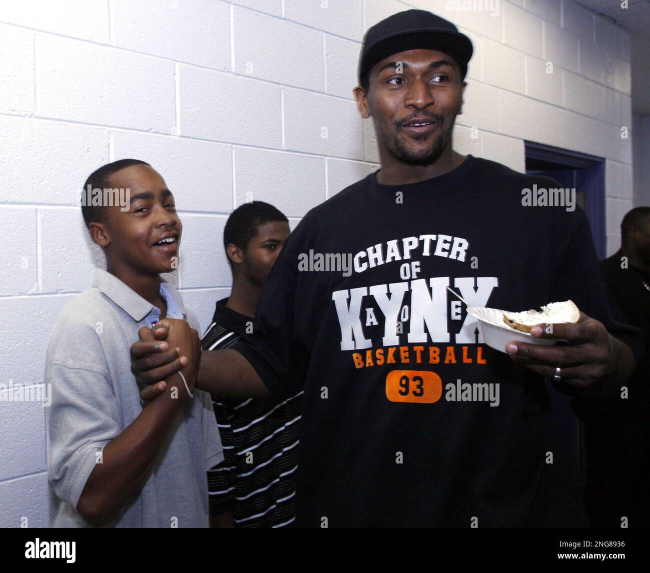 NBA star Ron Artest shakes hands with a young member of the Mathis ...