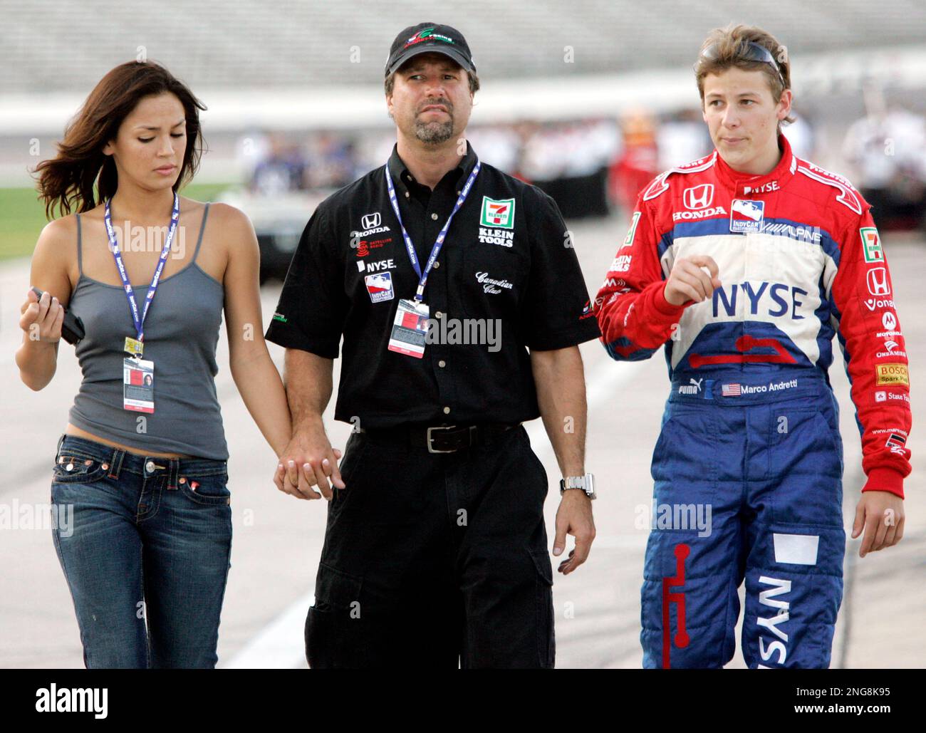 Michael Andretti, center, walks down pit road with his girlfriend model ...