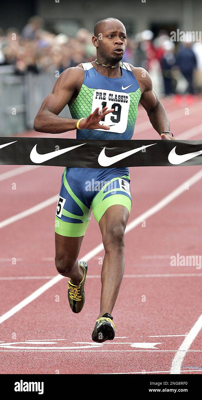 Sprinter Asafa Powell, from Jamaica, hits the tape in his heat of the ...