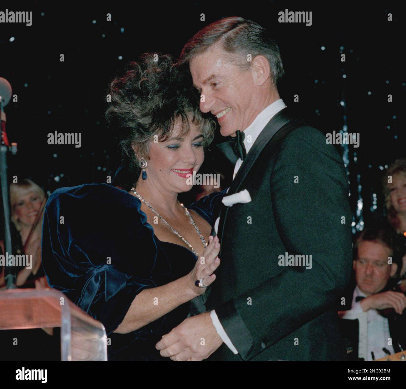 Actress Elizabeth Taylor hugs actor Roddy McDowall after presenting him ...
