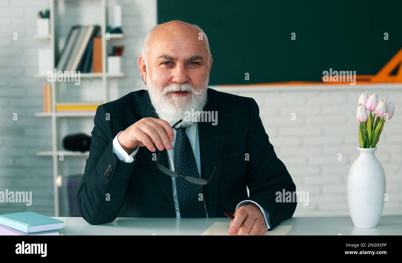 Senior academic professor on lecture near empty blackboard. Knowledge ...