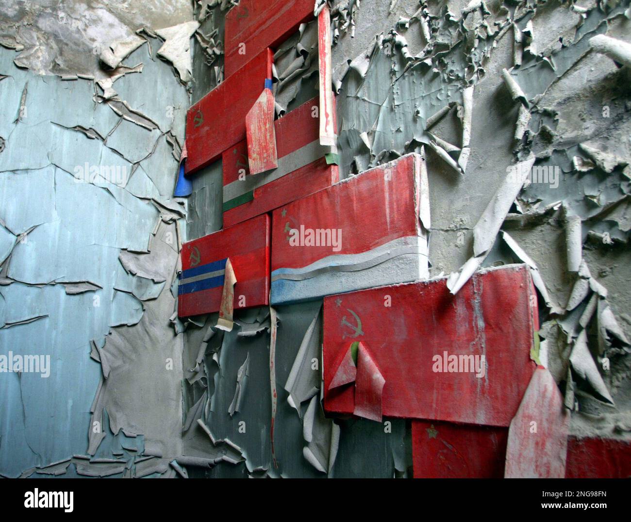 Red Soviet symbolic flags are placed on a dilapidated wall in a school ...