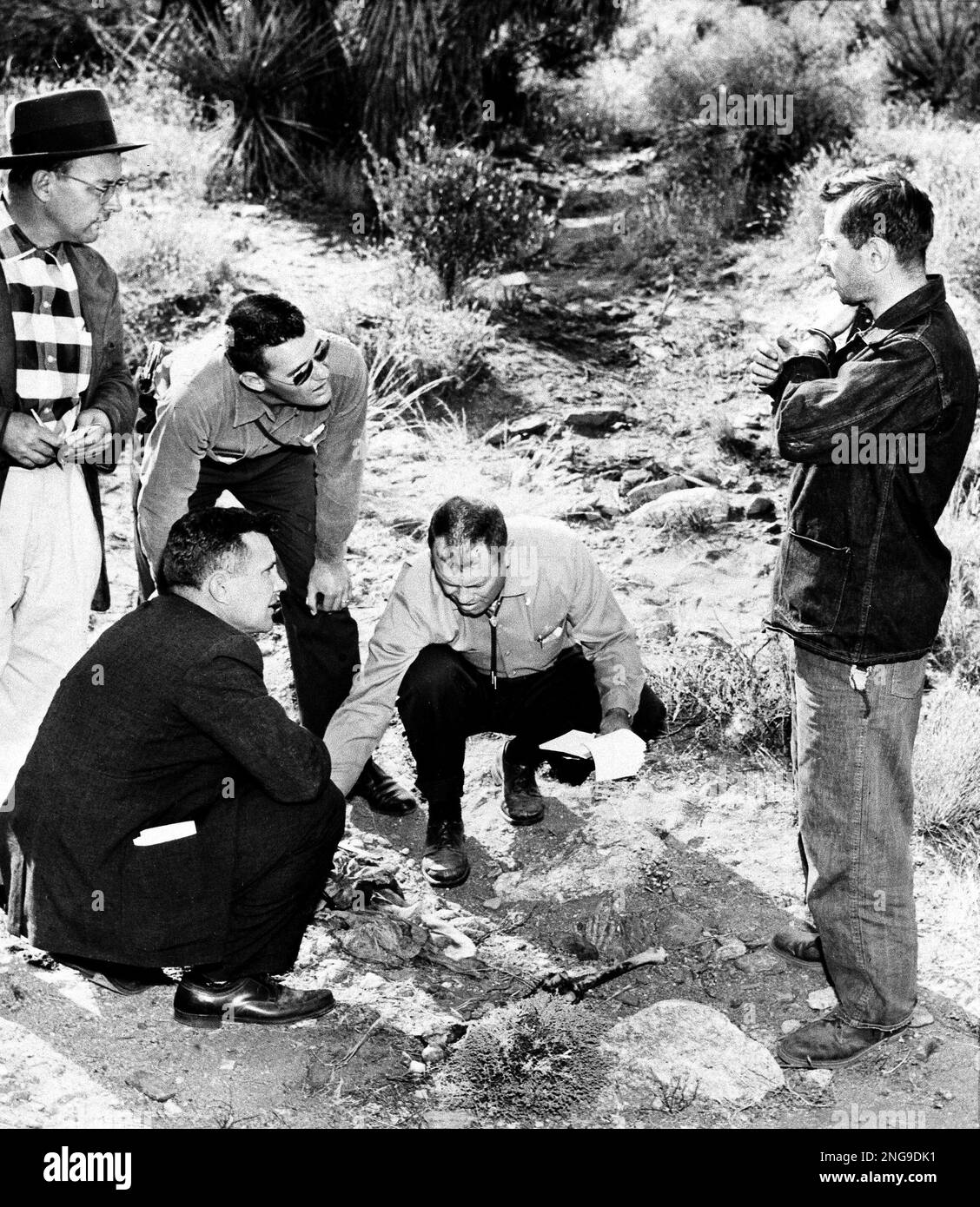Harvey M. Glatman, 30, at right, stands over bones, in San Diego, Calif ...