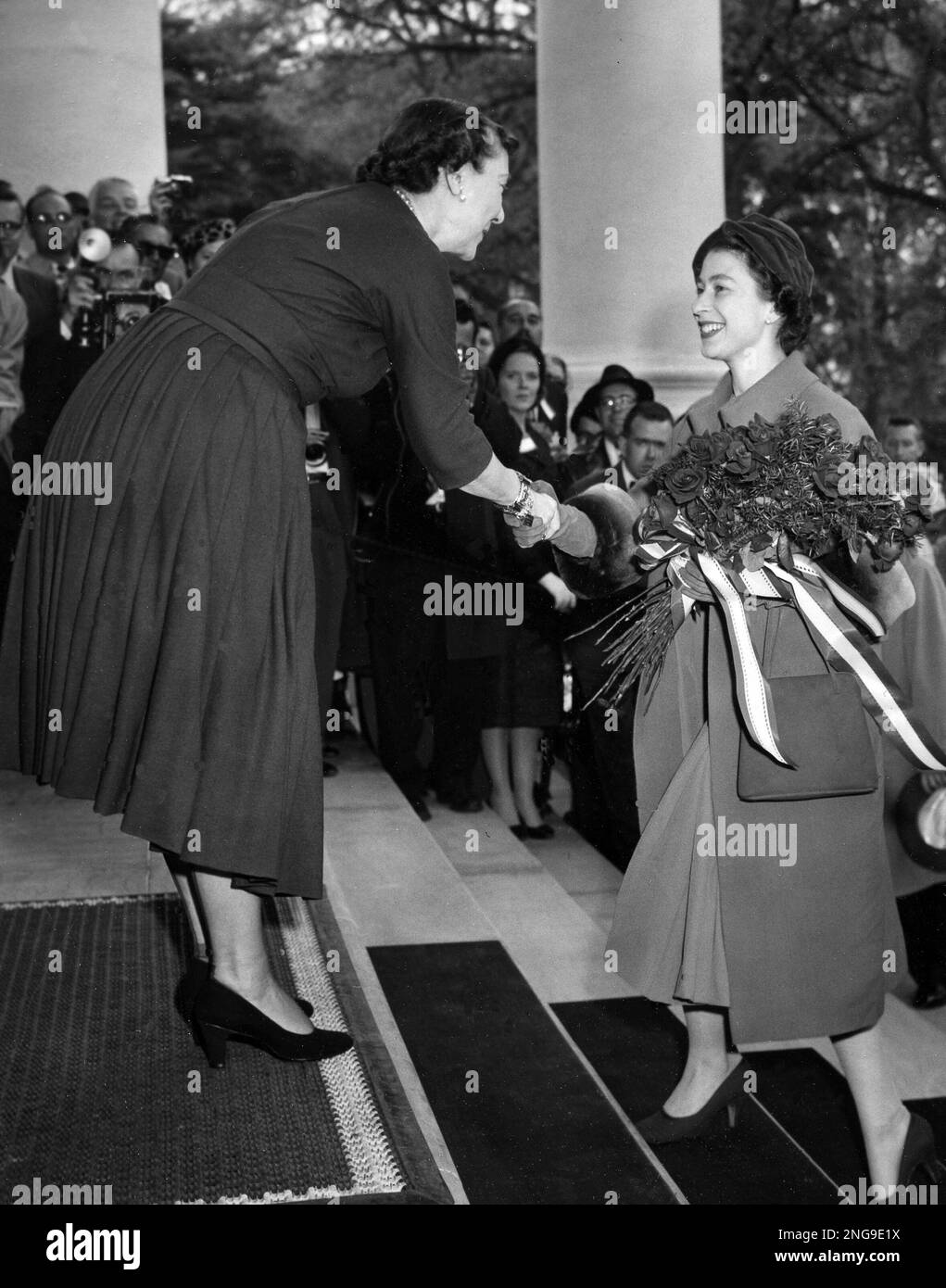 First lady Mamie Eisenhower shakes hands with Queen Elizabeth II as she ...