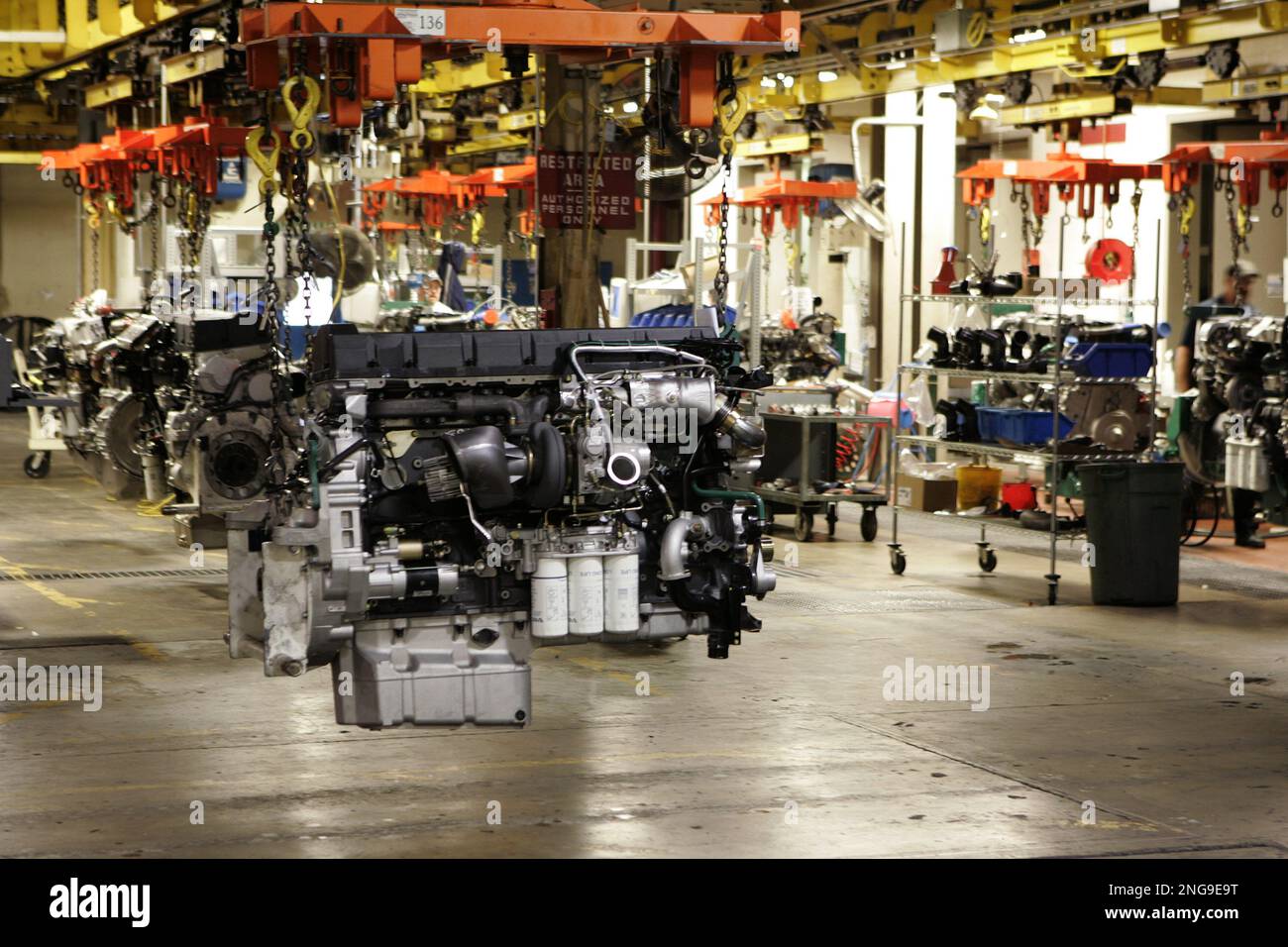 A row of Volvo diesel truck engines travel along an assembly line ...