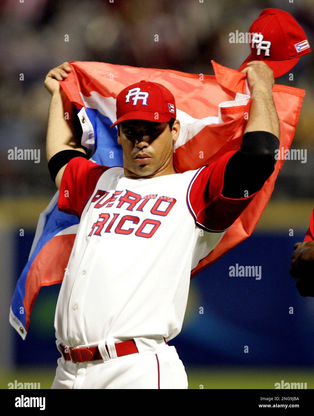 Team Puerto Rico outfielder Ricky Ledee carries Puerto Rico's flag ...