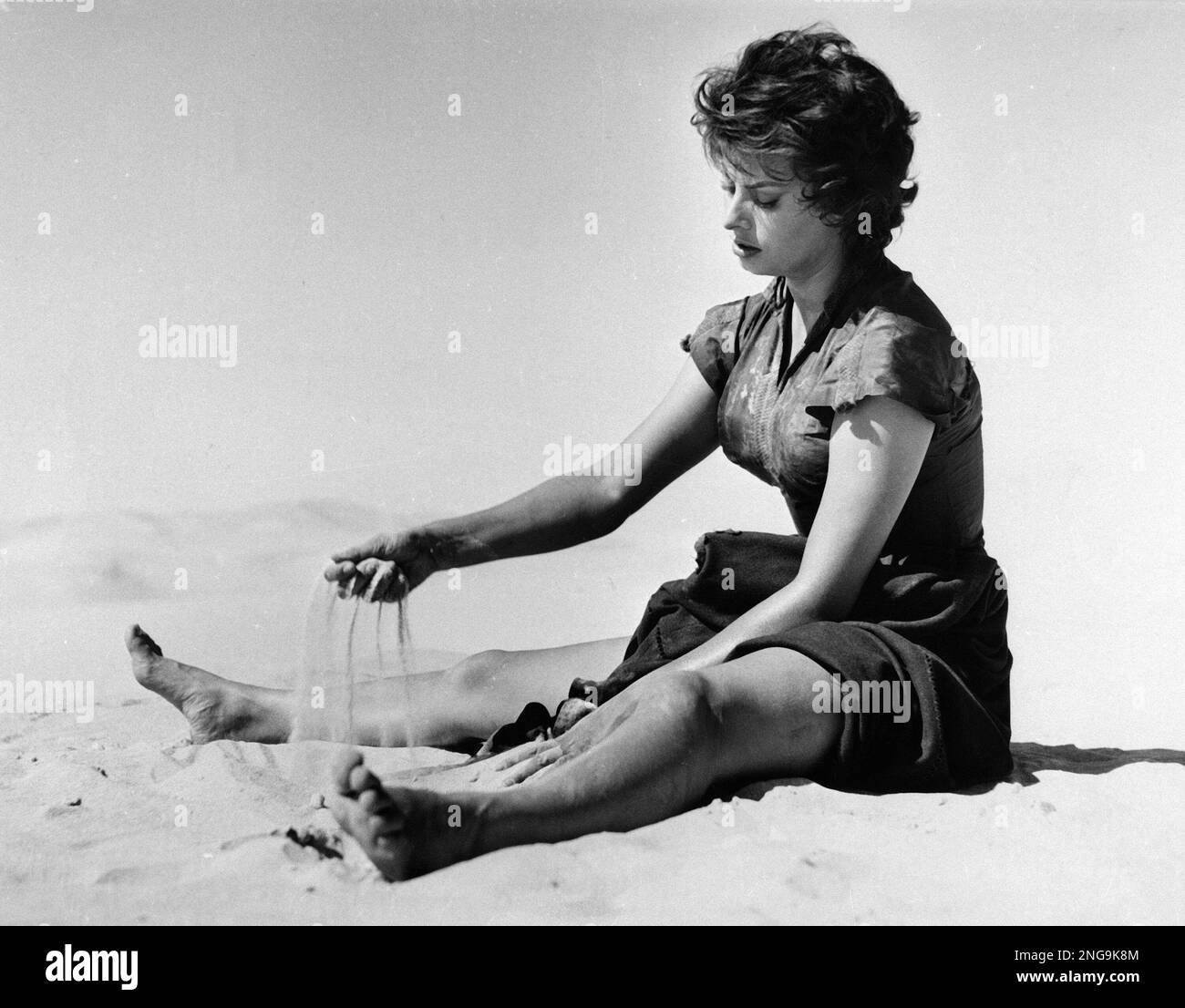 Italian actress Sophia Loren sits in the sand of the Sahara Desert, in ...