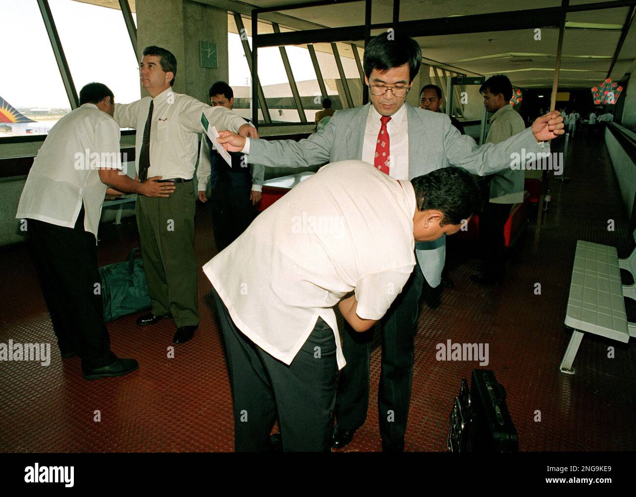 Airport security frisk departing passengers at the Ninoy Aquino ...