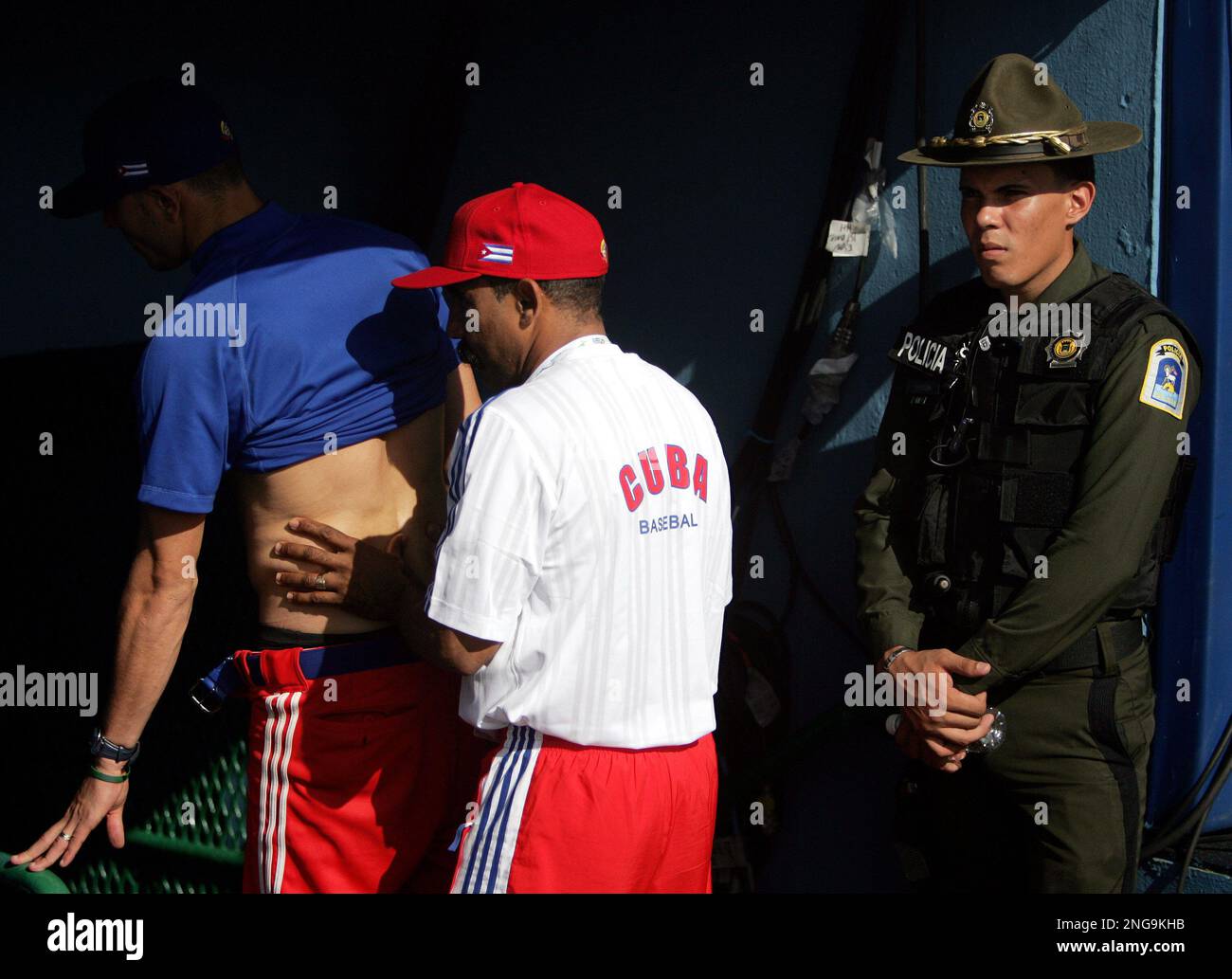 A Team Cuban player receives treatment on his back in the dugout during ...