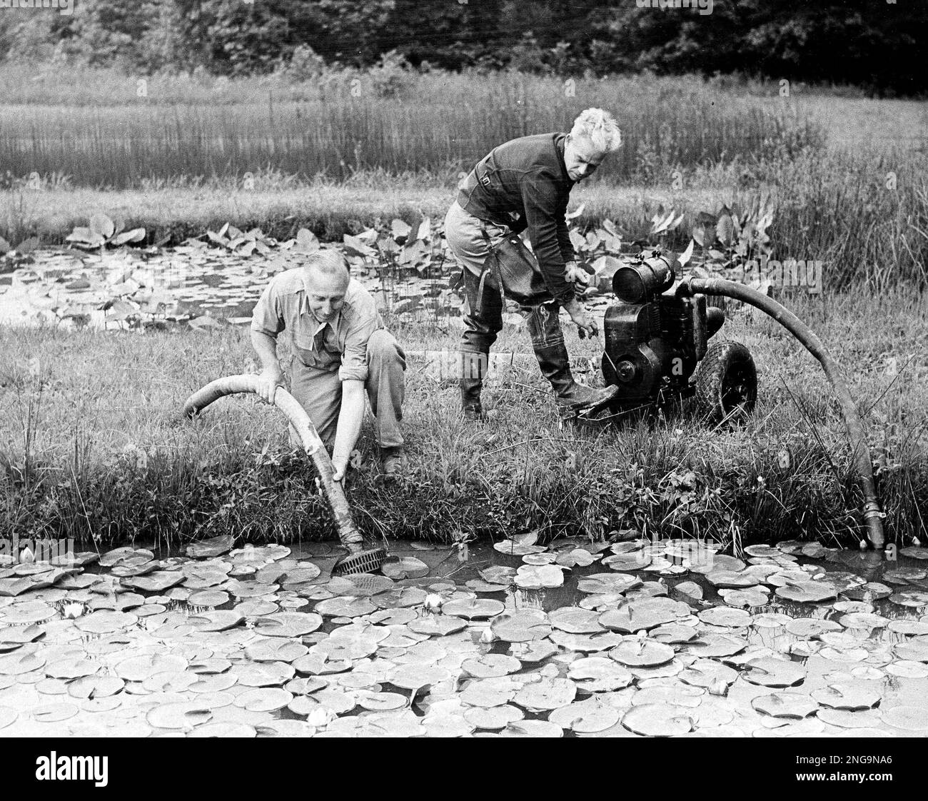 Eugene Surber, left, and Francis Uhler, pump an artificial pond with ...