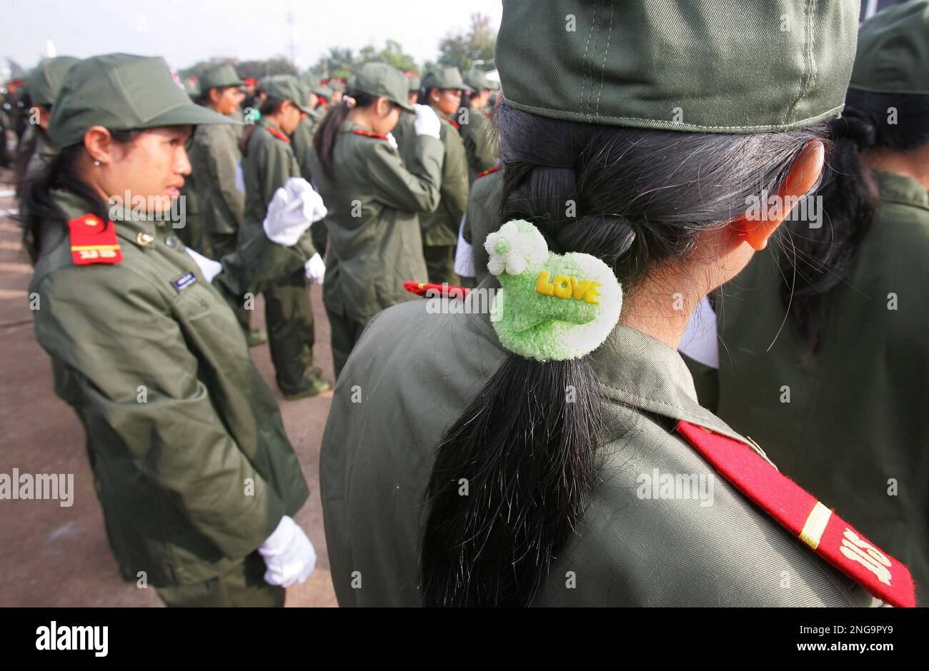 "Love" is worn in the hair of a female Lao Army soldier during a ...