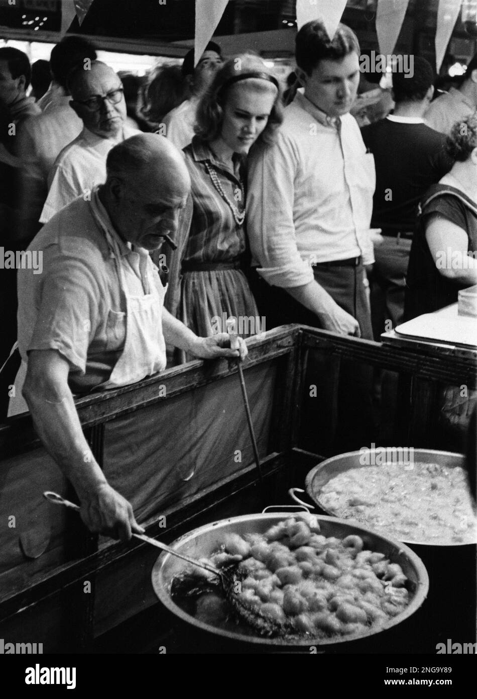 A vendor fries zeppoles as customers wait, during the Feast of St ...