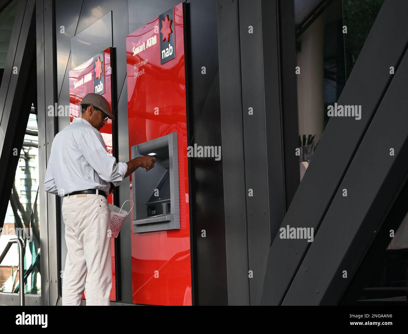 A middle aged South Asian man using a NAB smart ATM in Melbourne Stock ...