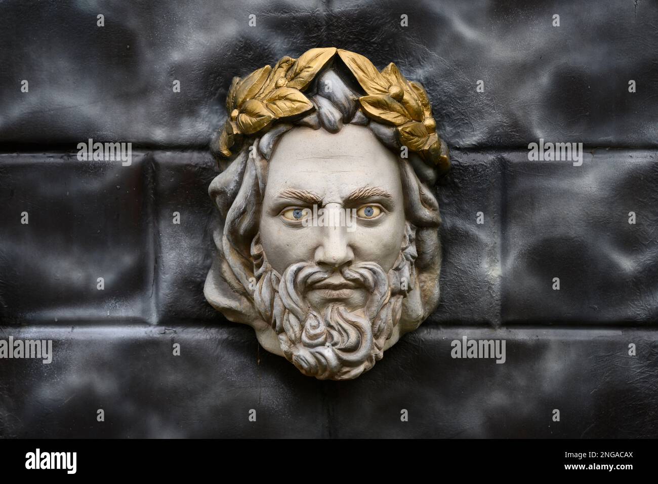 Bas-relief of the head of an ancient Greek god on the wall of a ...